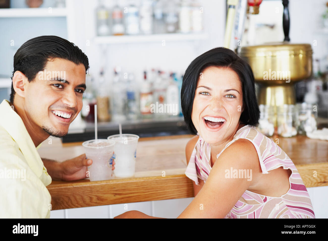 Young couple laughing at bar Stock Photo - Alamy