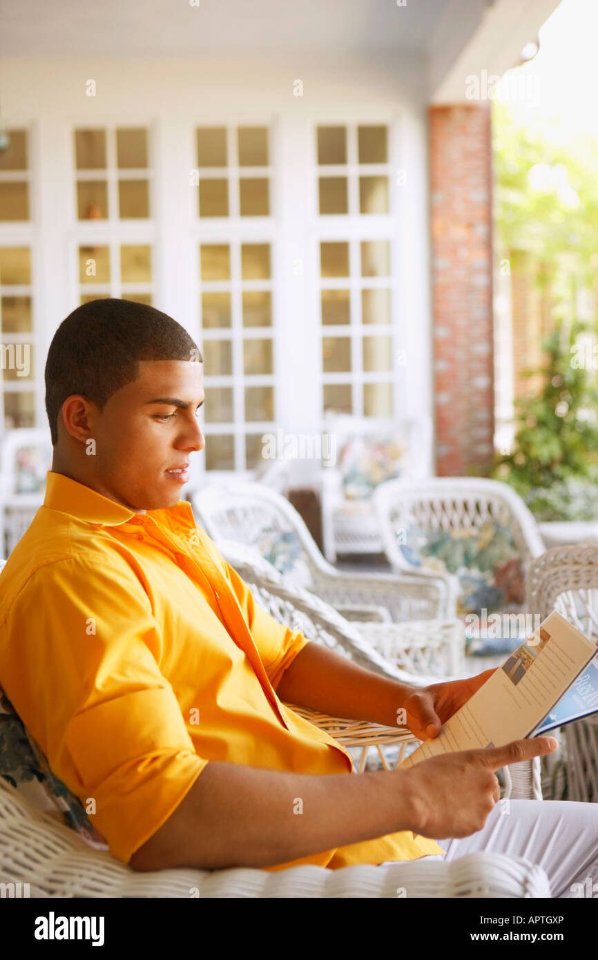 Hispanic man reading magazine Stock Photo - Alamy