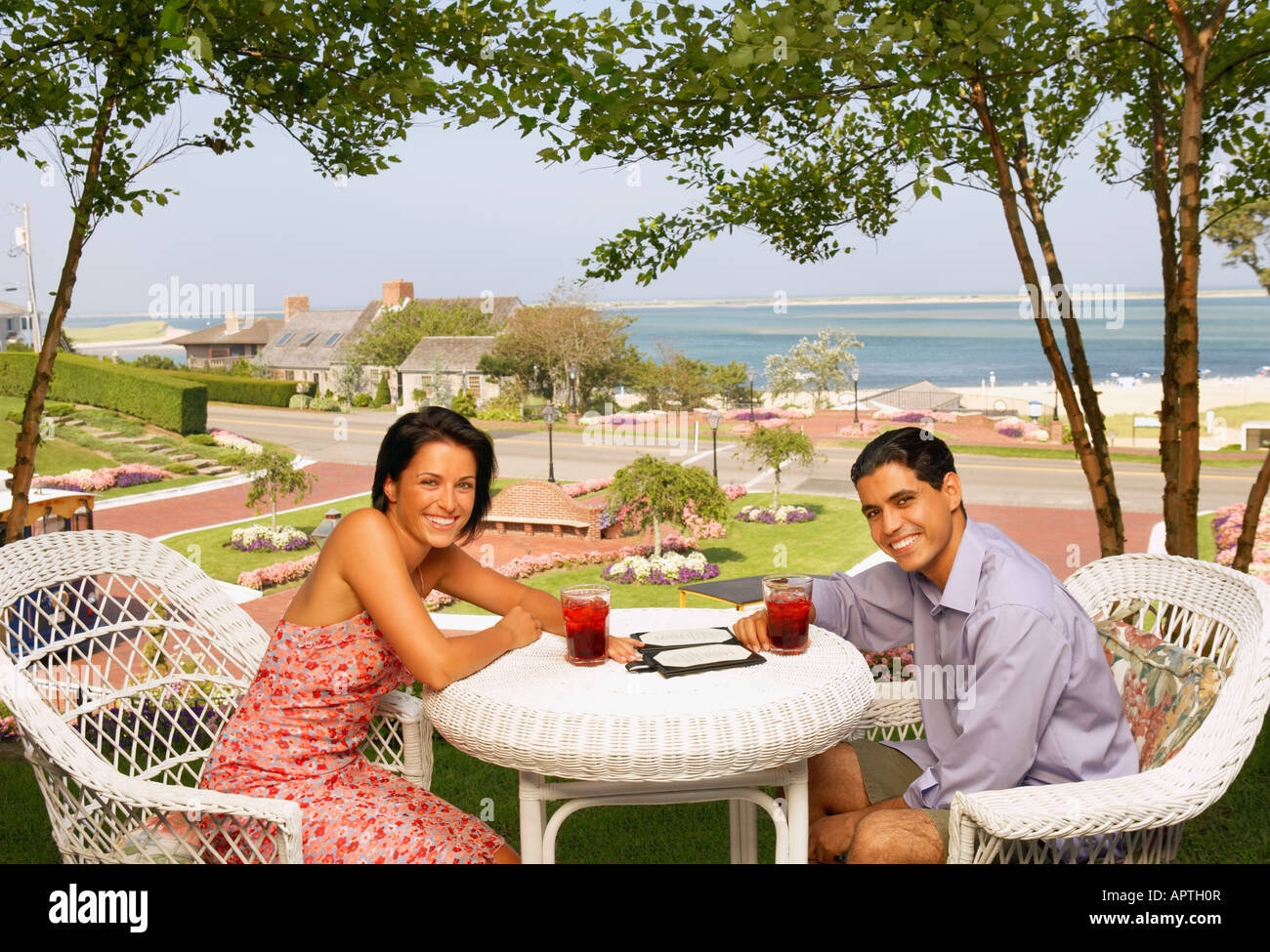 Young couple eating at beach resort Stock Photo - Alamy