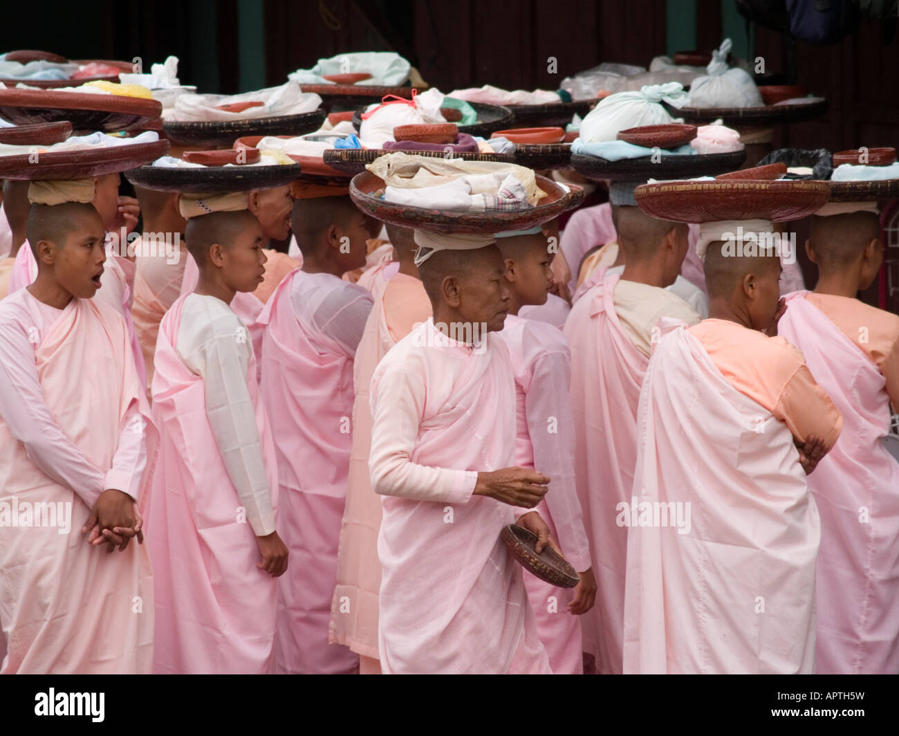 nuns standing in line for alms in the old city of Bagan in Myanmar ...