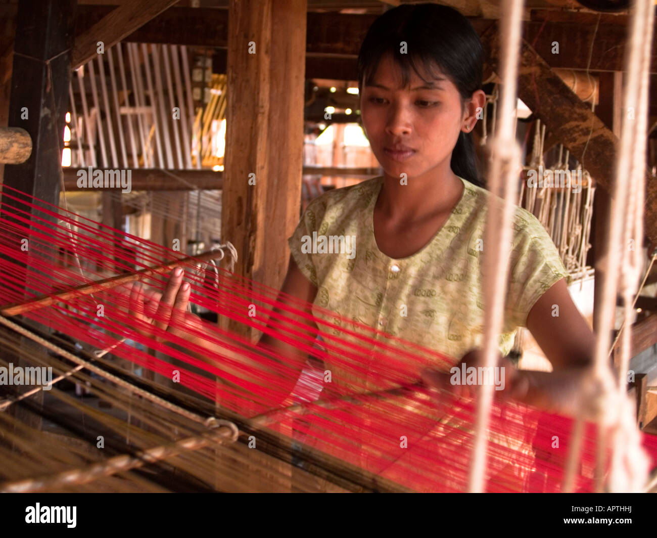 woman weaving lotus threads into silk on her loom at Inle Lake in ...