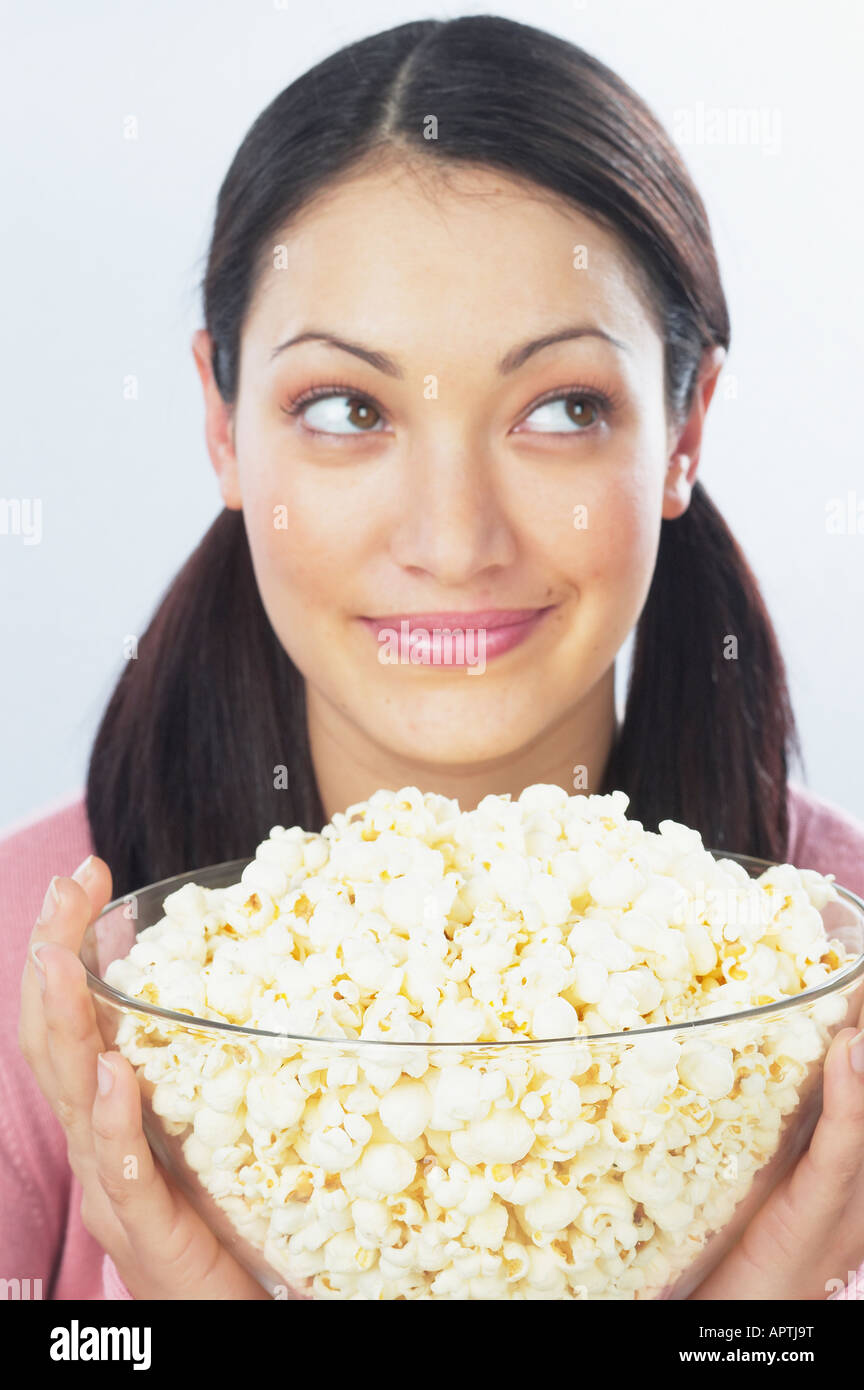 Young woman holding bowl of popcorn Stock Photo - Alamy