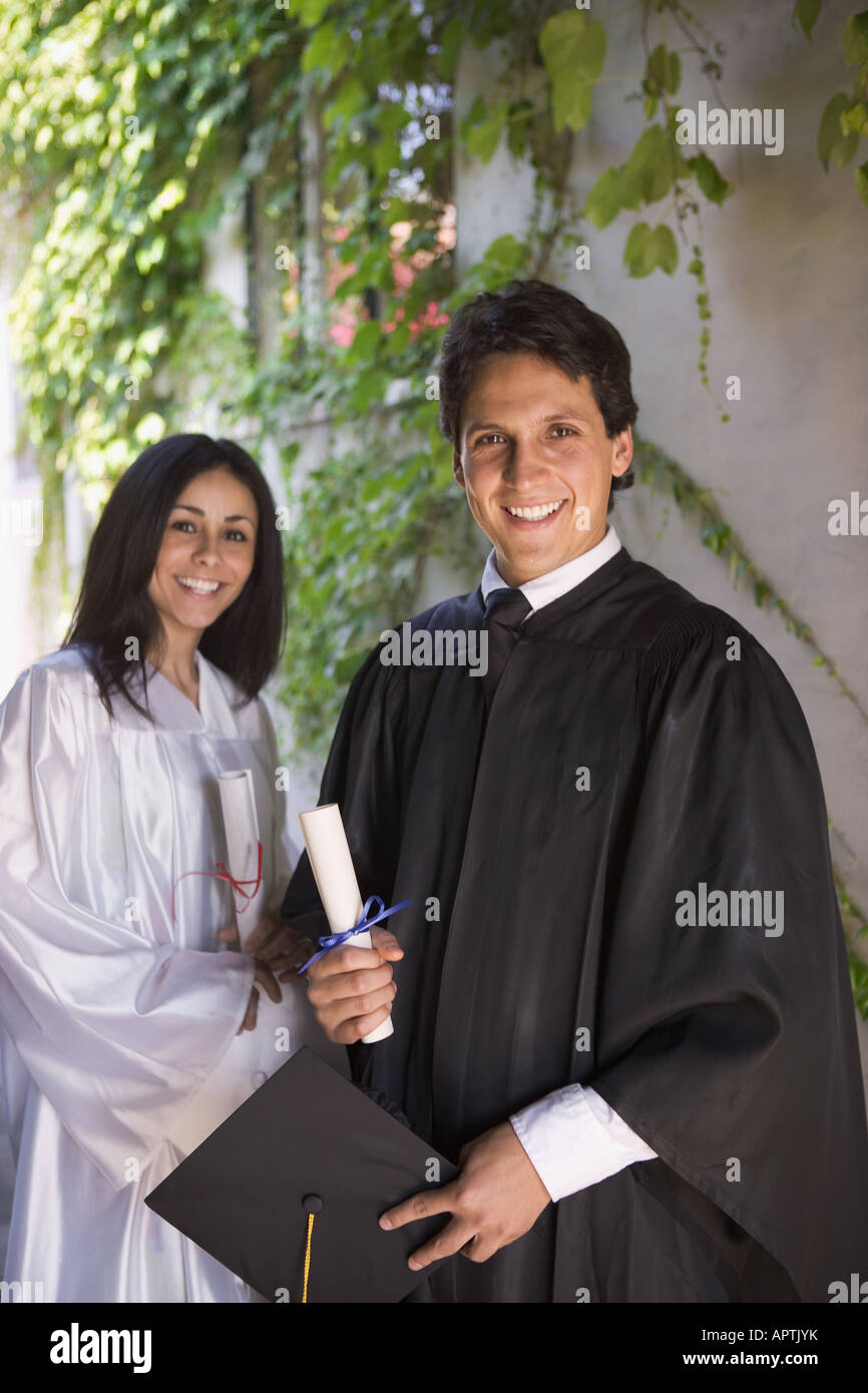 Graduating man and woman holding diplomas Stock Photo - Alamy