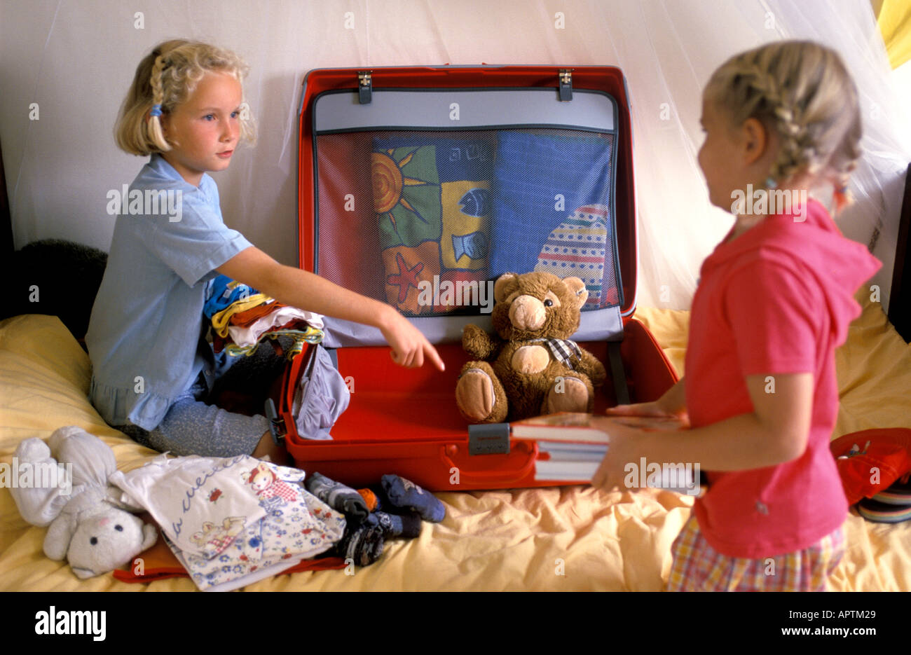 Two girls packing their suitcase for vacation Stock Photo - Alamy