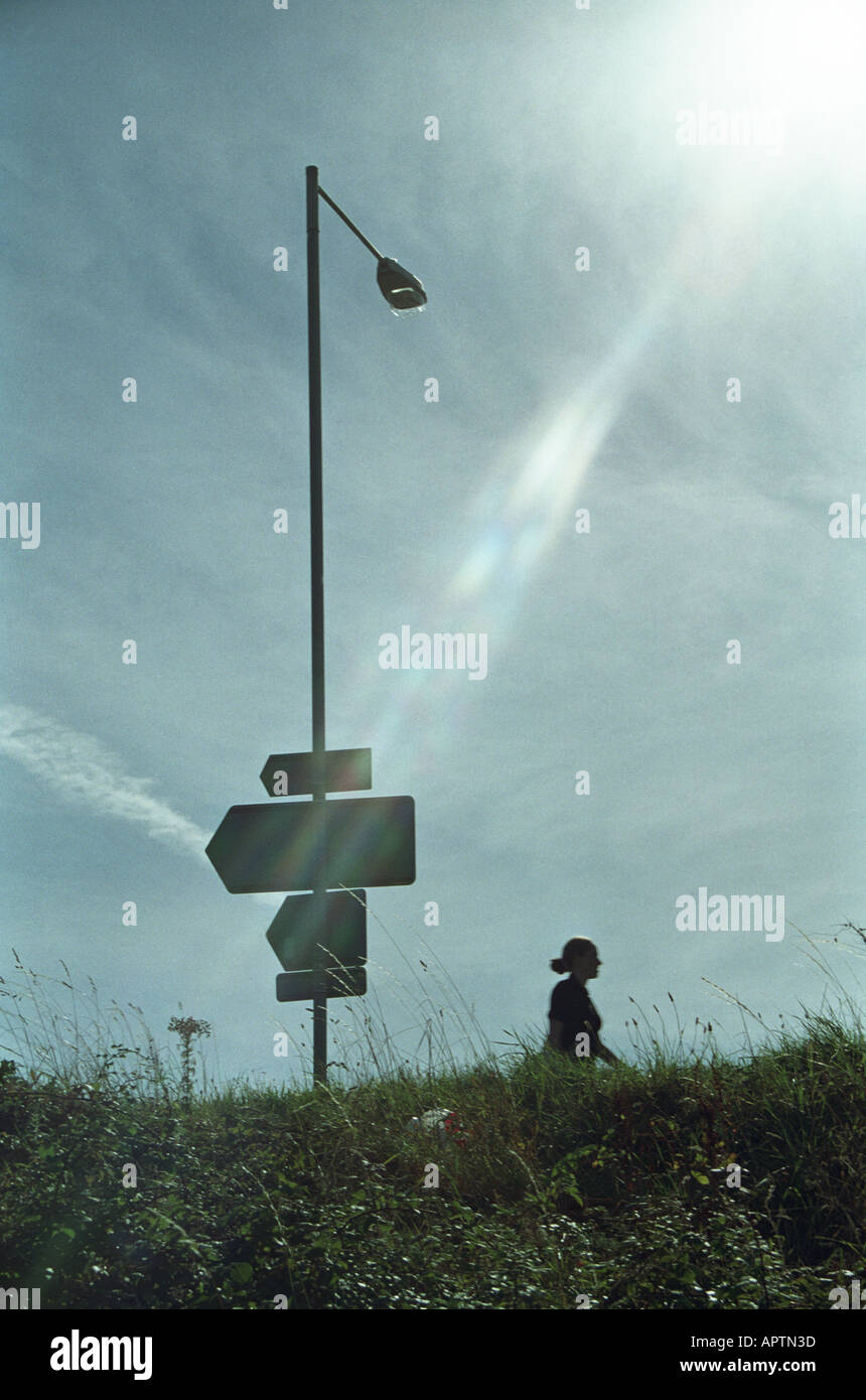 Woman walking past traffic signs hi-res stock photography and images ...
