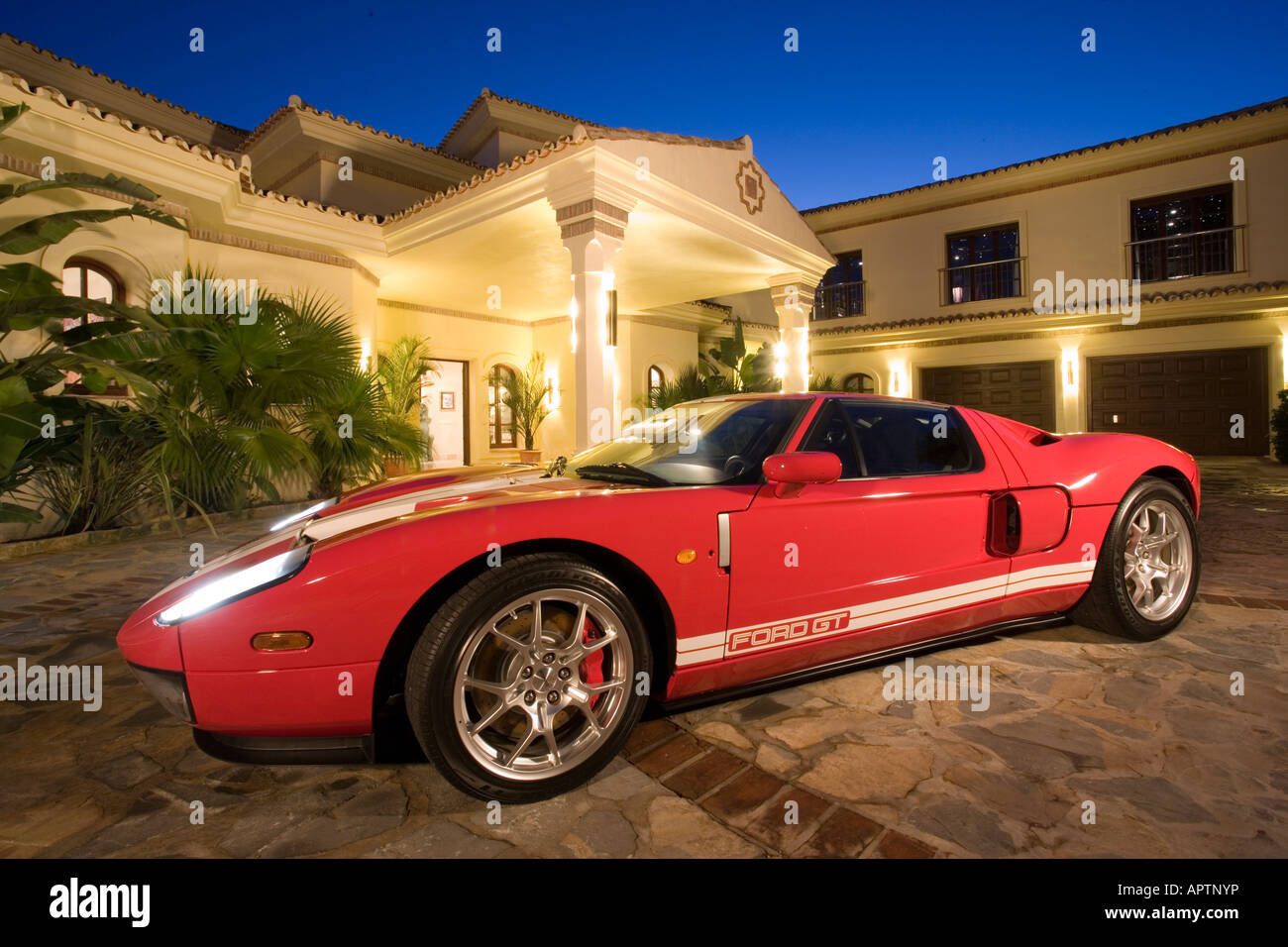 Modern Spanish villa with super car Ford GT40 in foreground at dusk ...