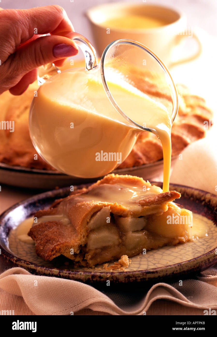 Old fashioned apple pie with hand pouring custard from jug Stock Photo ...
