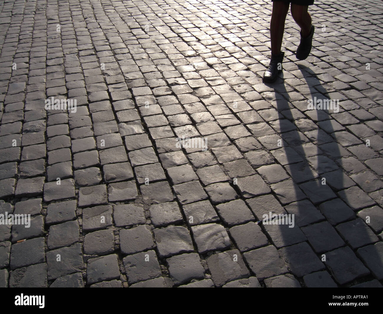 shadow of child running on cobbled street Stock Photo - Alamy