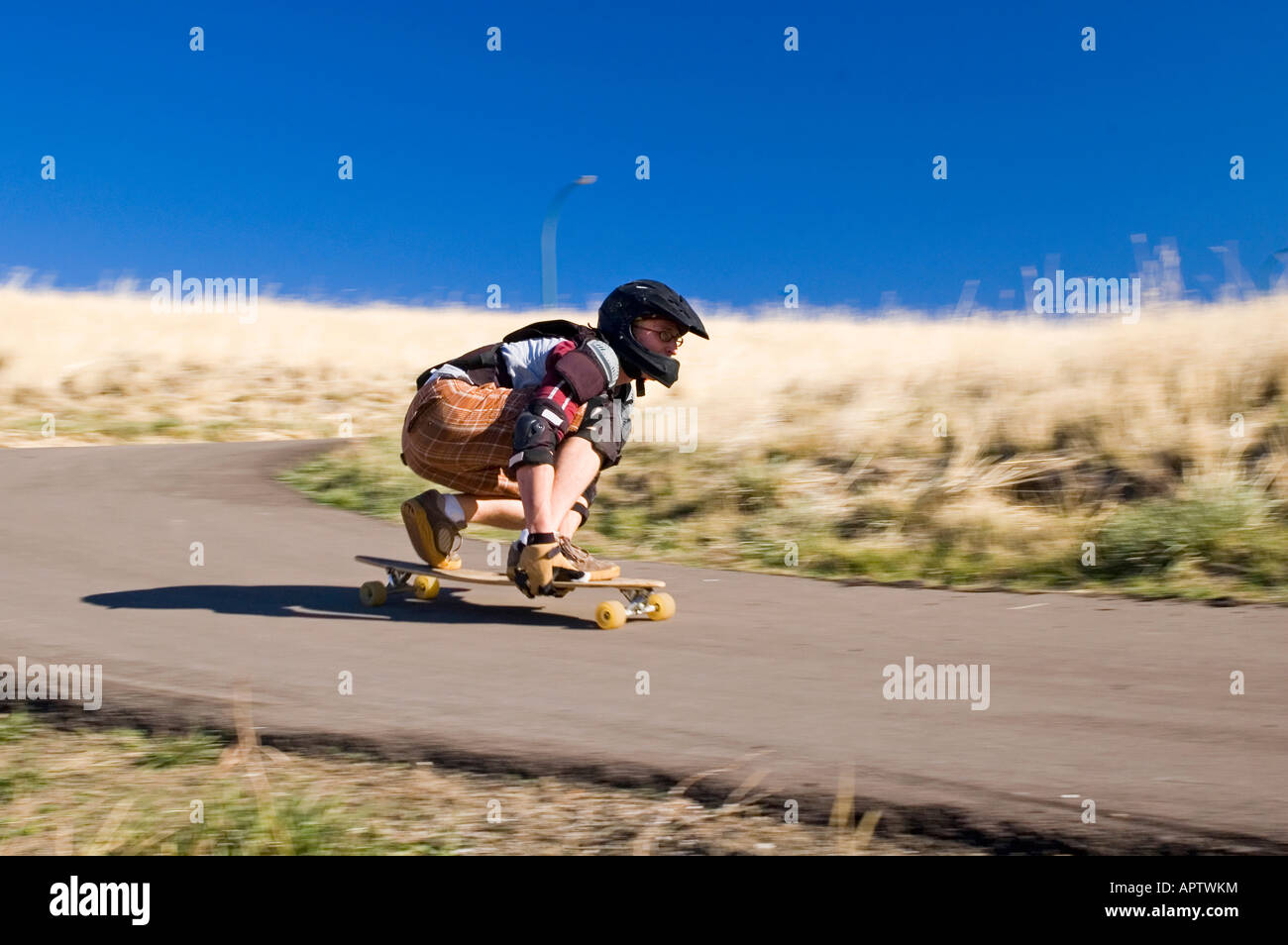 Young man long boarding down a steep path Stock Photo - Alamy