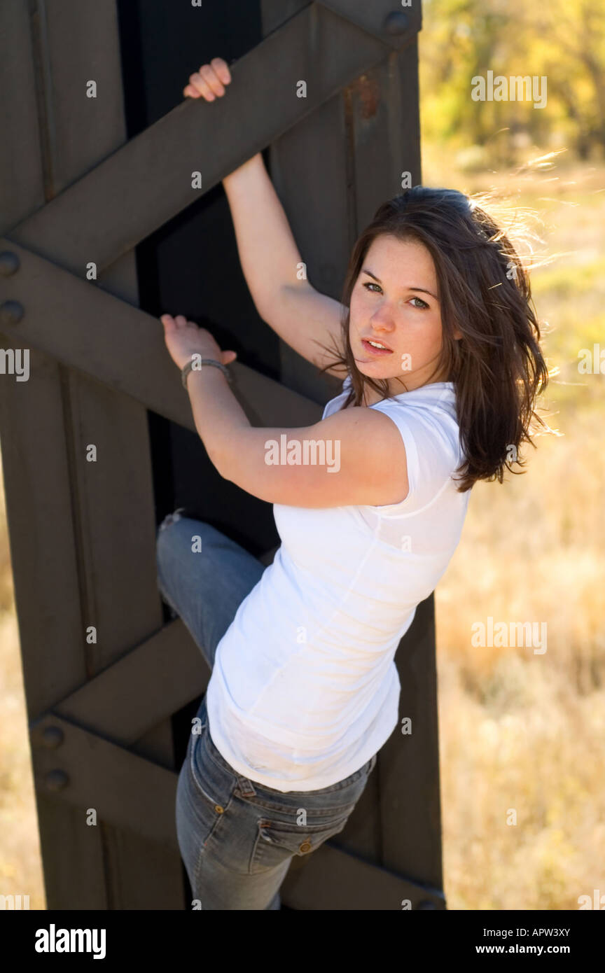 Young woman hanging from a bridge Stock Photo - Alamy