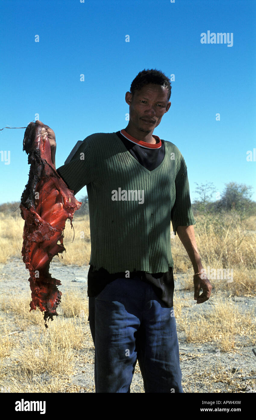 Bushman hunter carrying Oryx meat Bushmanland Namibia Stock Photo - Alamy