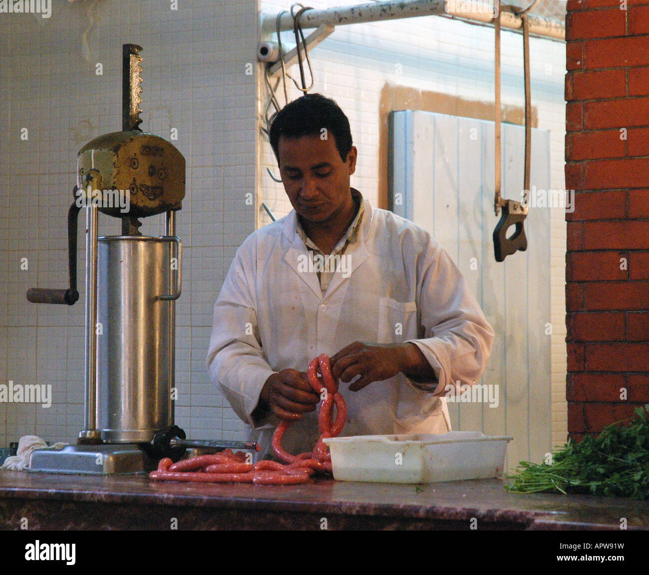 Butcher working at his stall in Marrakech preparing Sausages Stock ...