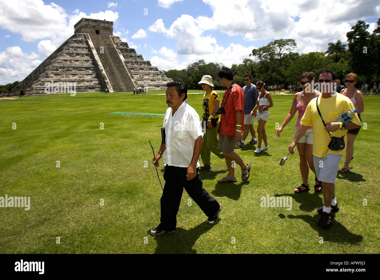 Visitors follow guide past Mayan El Castillo Kukulcan pyramid Chichen ...
