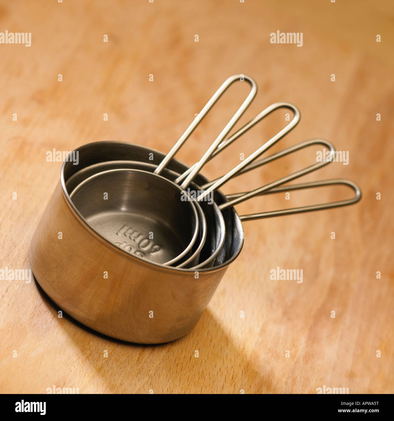 STAINLESS STEEL MEASURING TINS ON WOODEN TABLE Stock Photo - Alamy