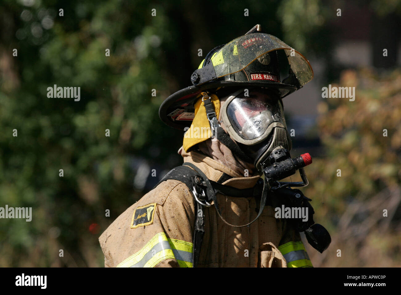 An American firefighter investigating a structure fire while holding ...