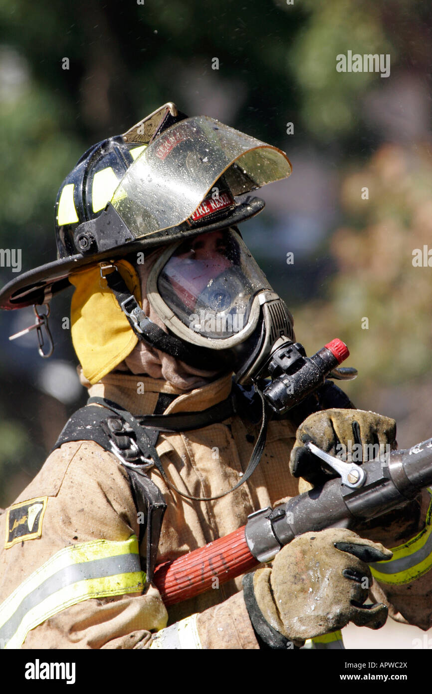An American firefighter on a hoseline pumping and spraying water onto a ...