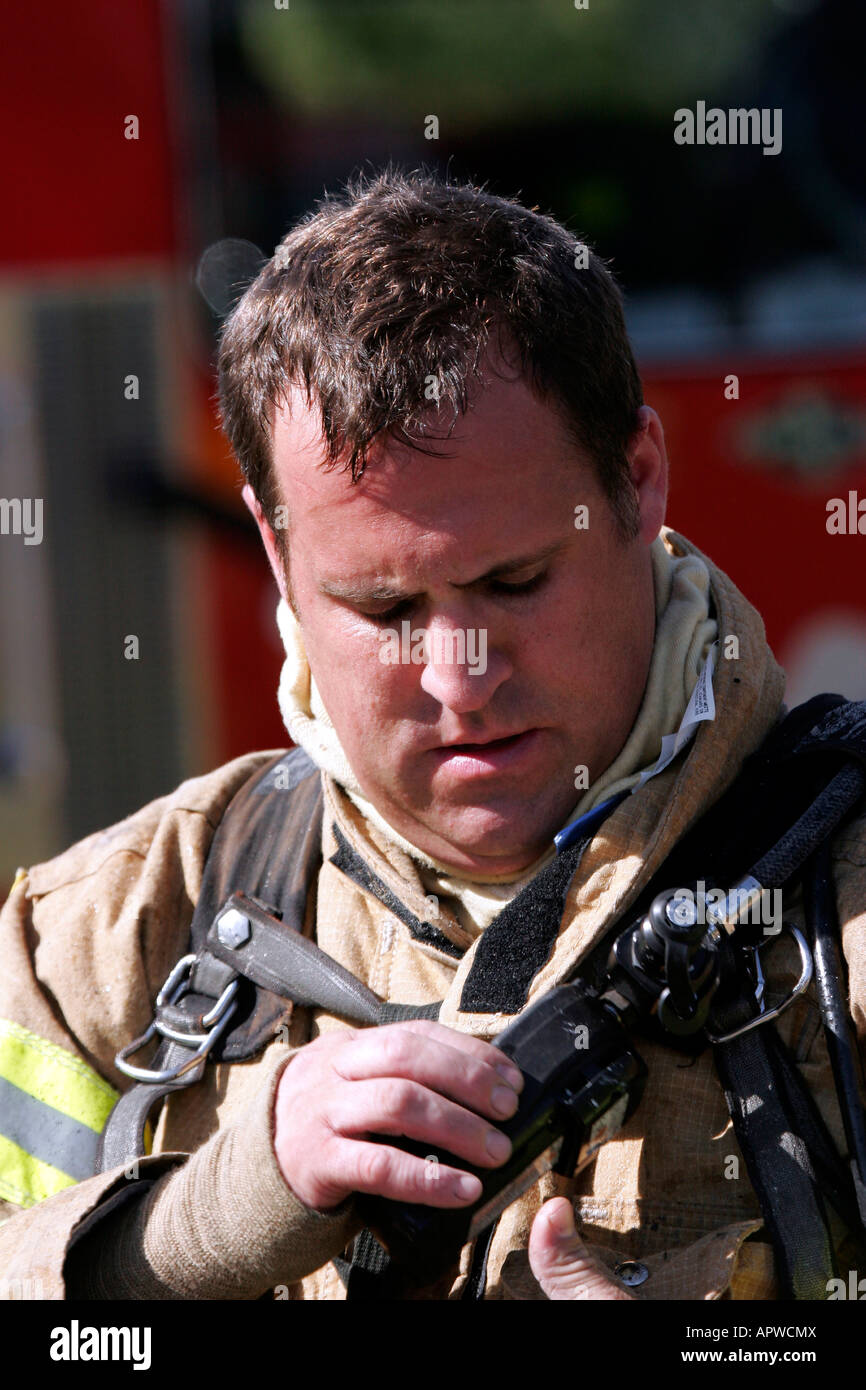 A firefighter checking his instruments on the breathing apparatus after ...