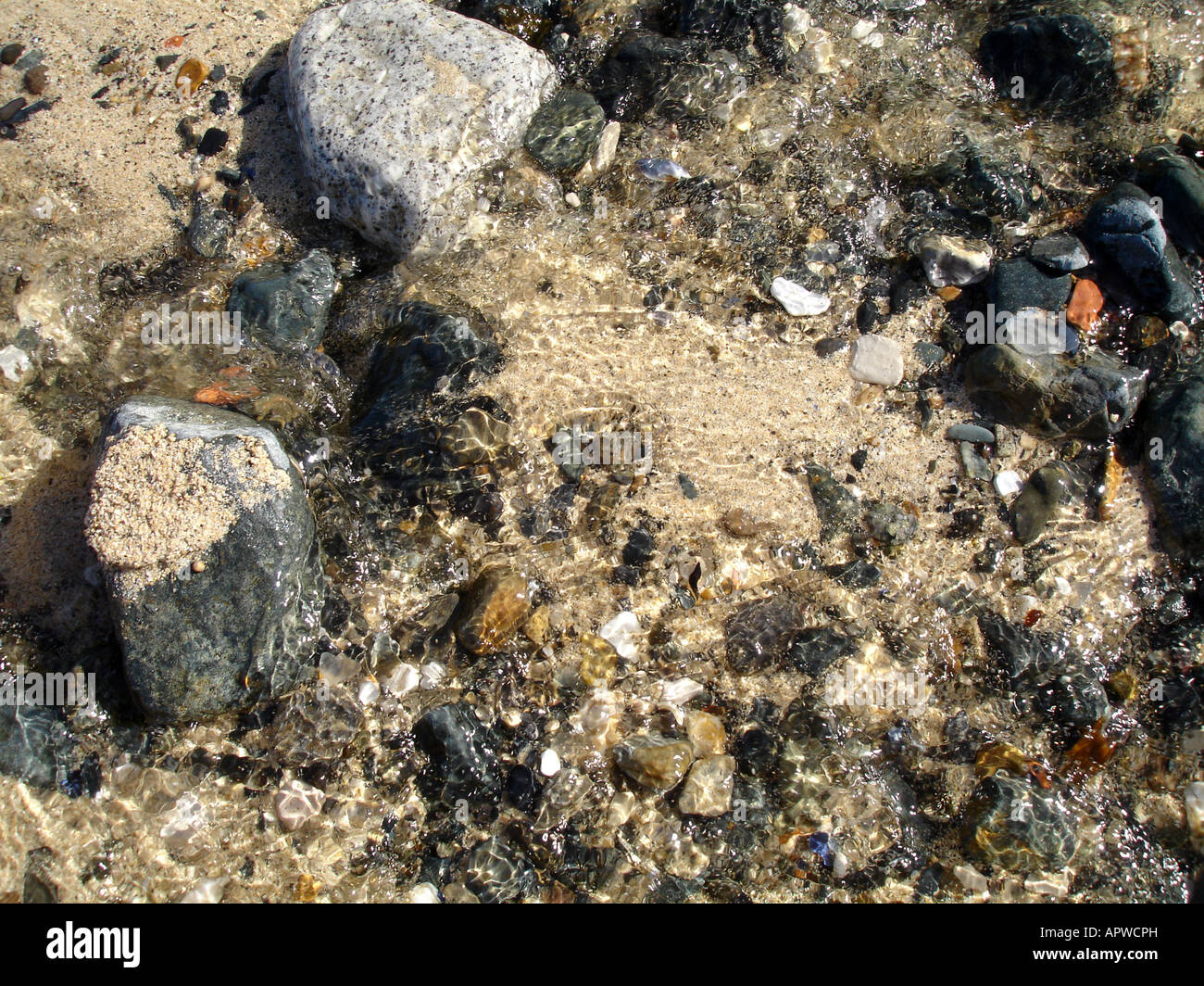 Pebbles and stones under a river flowing towards the sea Stock Photo ...