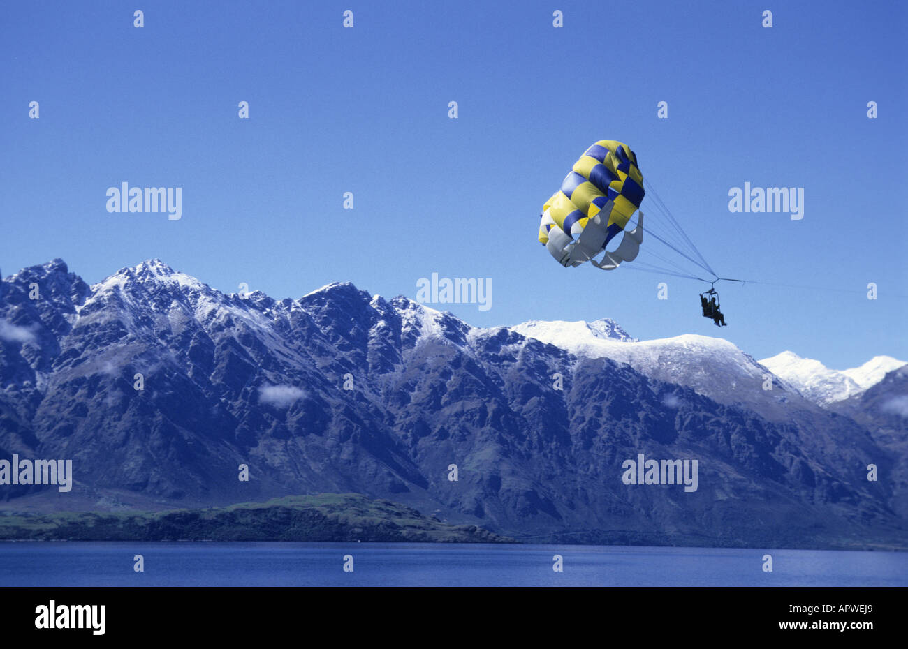 A parasailer being pulled by motorboat above Lake Wakatipu near ...