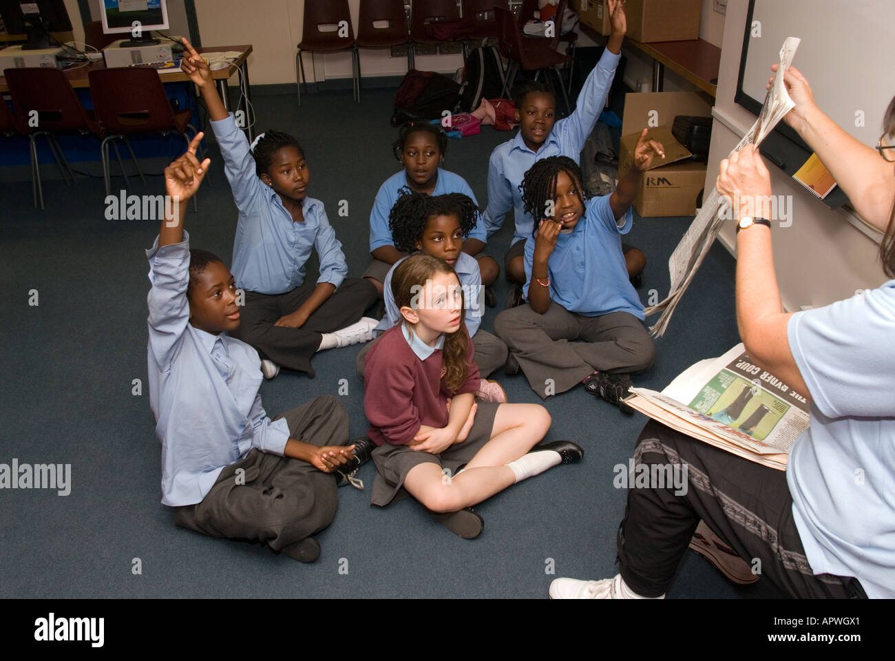 Primary school children attending newspaper group at after school club ...