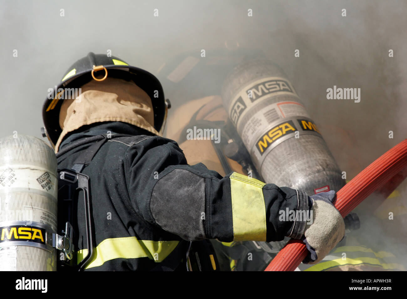 Firemen entering smoking building hi-res stock photography and images ...