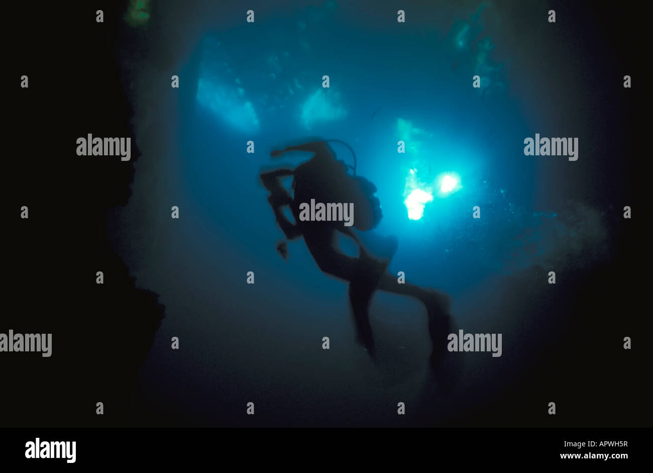Male scuba diver swims to surface toward mysterious distant lights ...