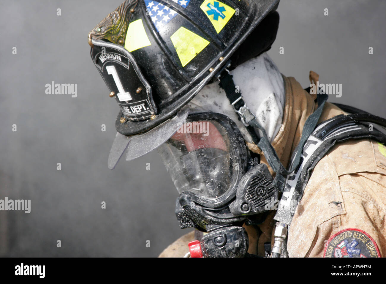 A firefighter on a scene of a structure fire surrounded by smoke Stock ...