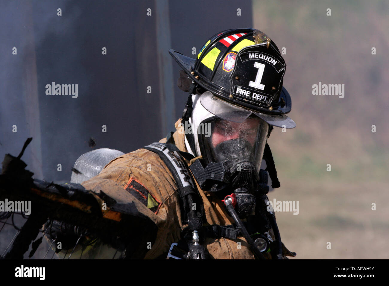 A Mequon Wisconsin firefighter removing burnt furniture debris from a ...