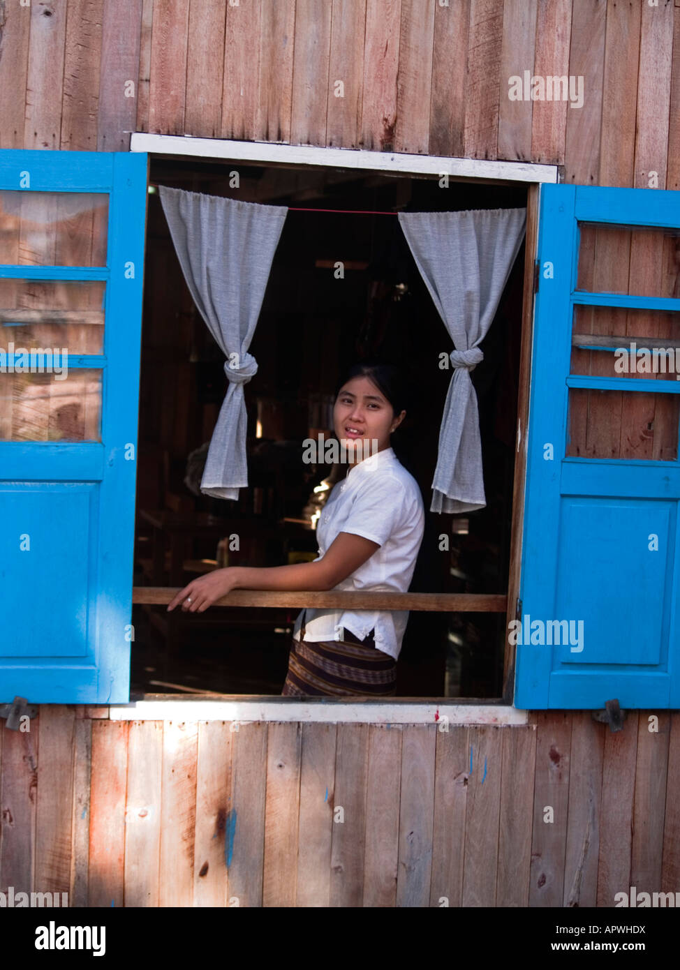 Burmese girl in the window of her old wood home on Inle Lake Stock ...