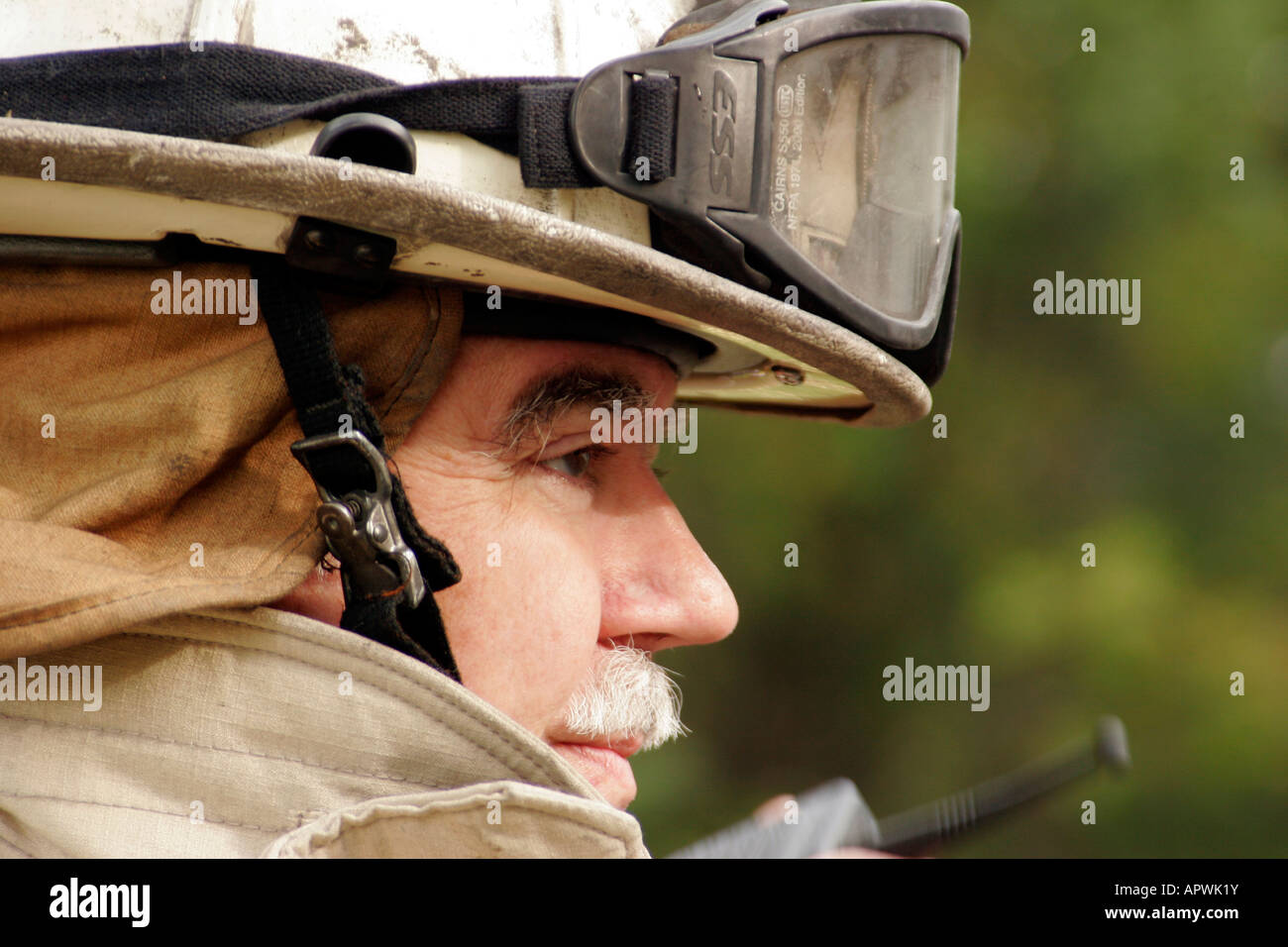 Fire Department Chief in white fire gear holding a walkie talkie ...