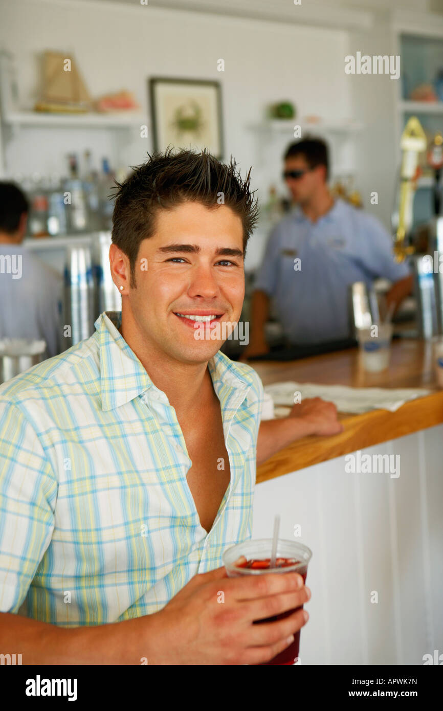 Young man drinking at bar Stock Photo - Alamy