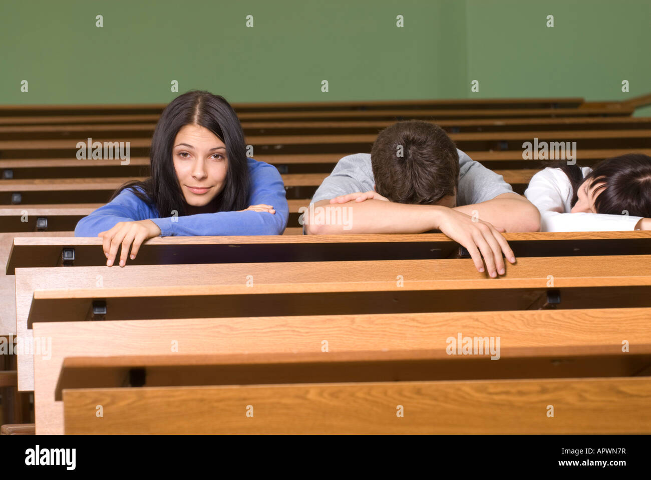 portrait of young student in lecture hall while all others are sleeping ...