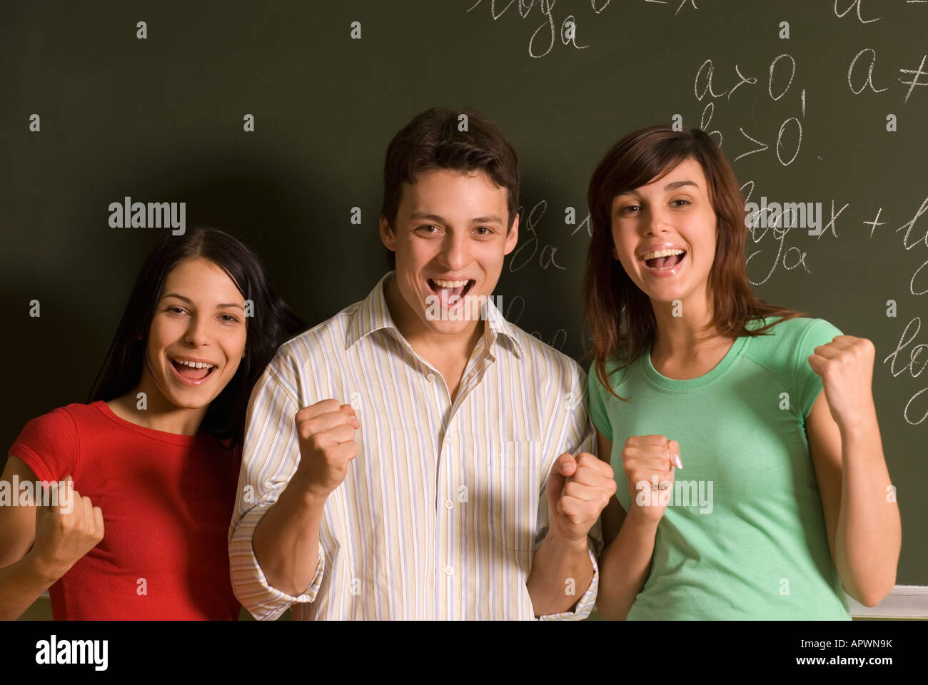group of three students celebrating in front of blackboard Stock Photo ...
