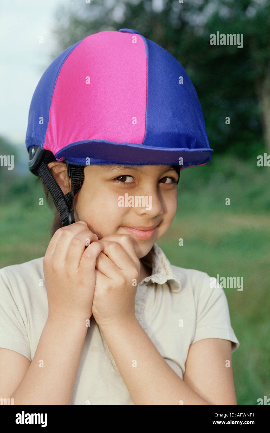 Girl adjusting riding hat Stock Photo - Alamy