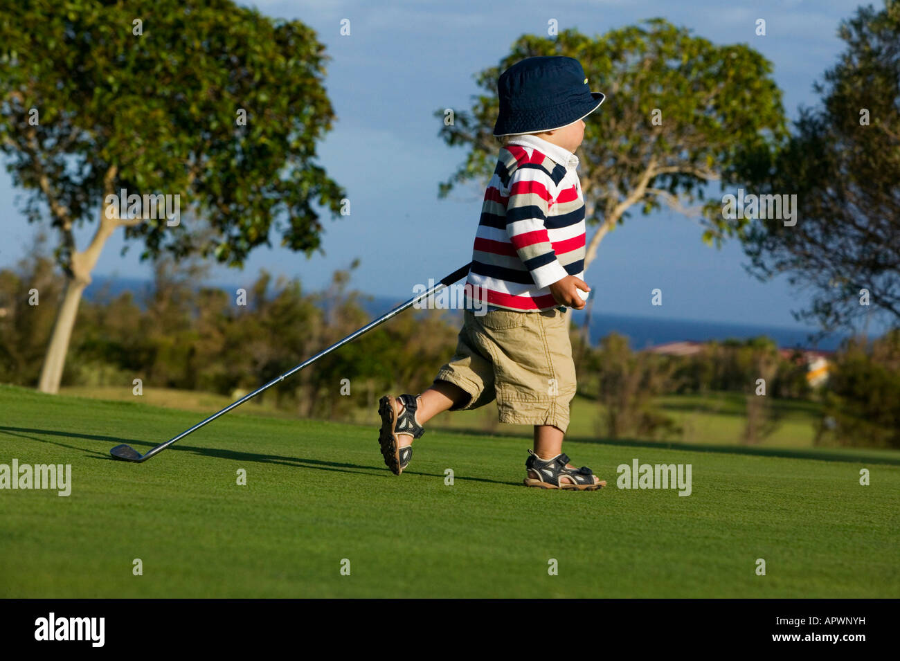 little boy running over golf course Stock Photo - Alamy