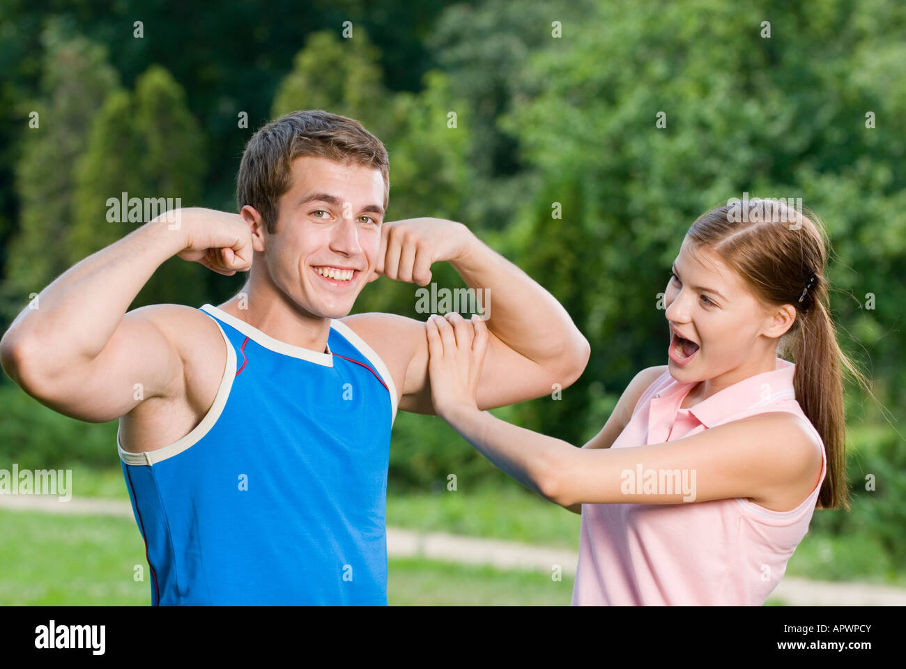 portrait of young woman touching bicep of boyfriend Stock Photo - Alamy