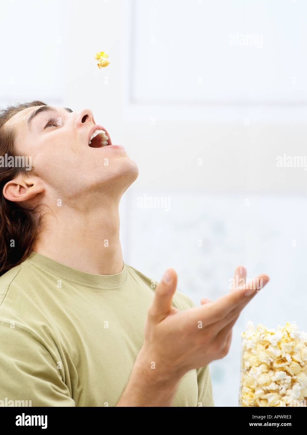 Young man eating popcorn Stock Photo - Alamy