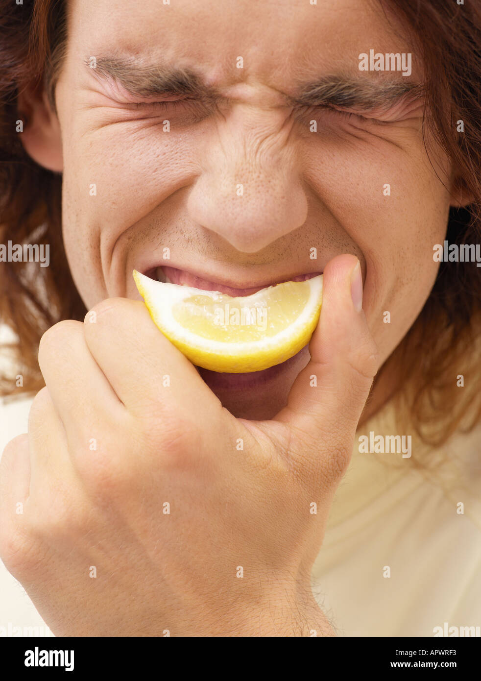 Man biting a slice of lemon Stock Photo - Alamy