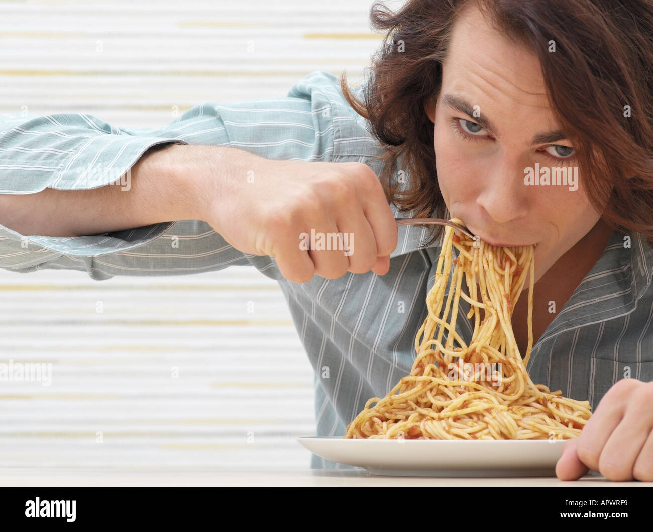Young man eating spaghetti Stock Photo - Alamy