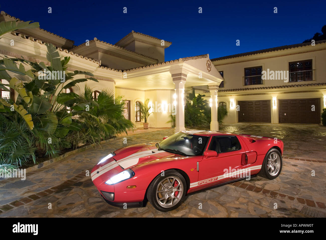 Modern Spanish villa with super car Ford GT40 in foreground at dusk ...