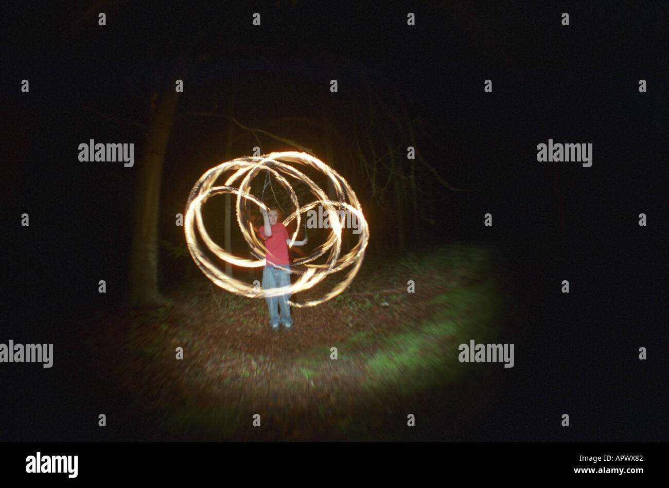 A Young Male uses fire Poi chains to create a crazy effect Stock Photo ...