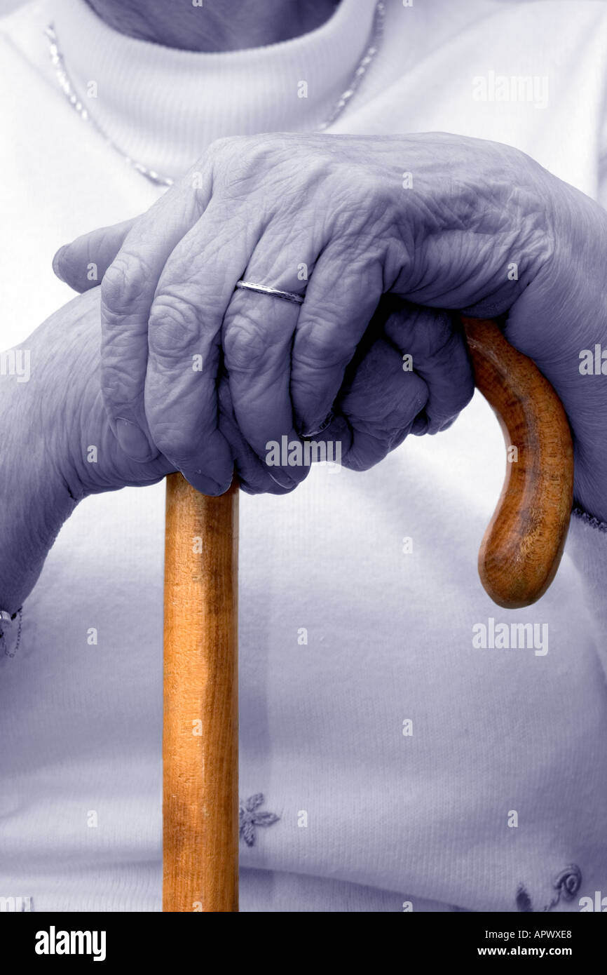 Octagenarian lady. Hands rest on walking stick. Elderly. Hypothermia ...