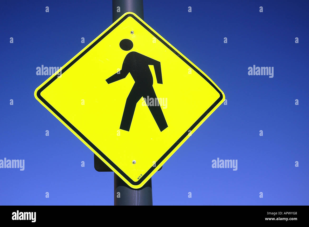 Yellow and black crosswalk sign with blue sky Stock Photo - Alamy