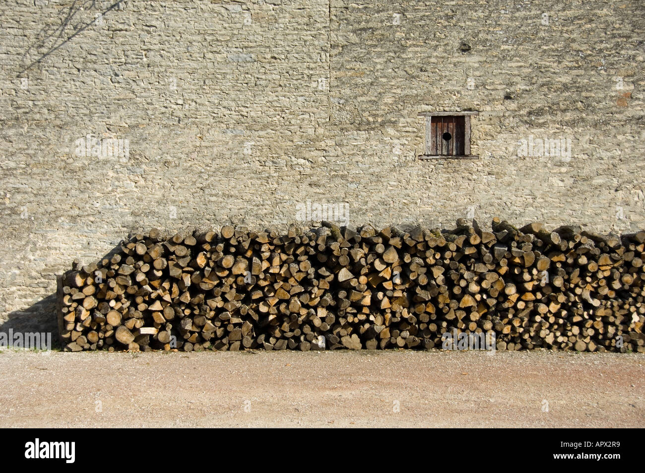 Wooden logs neatly stored outside a medieval farm building in the ...