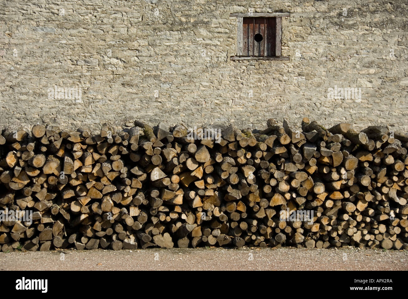 Wooden logs neatly stored outside a medieval farm building in the ...