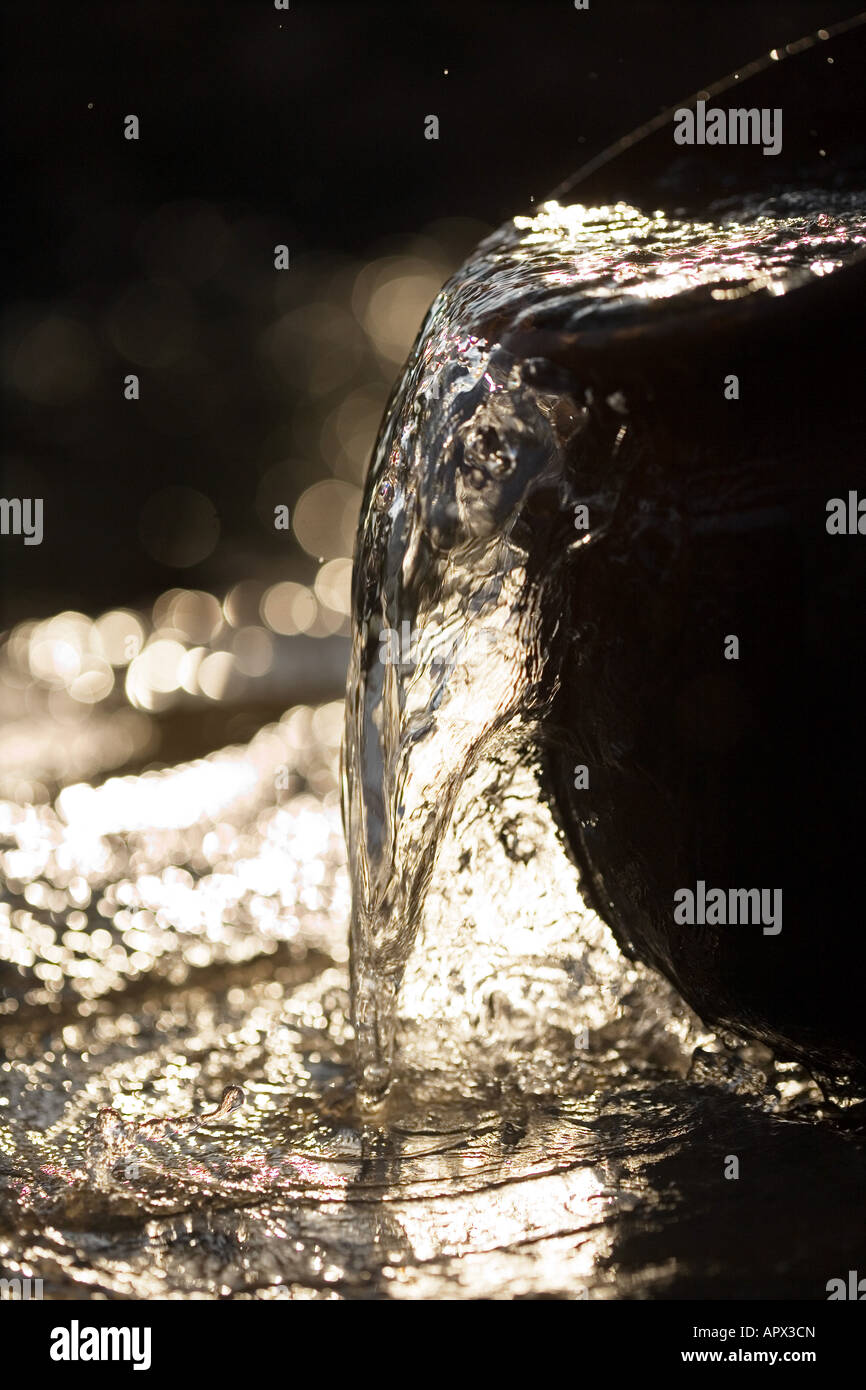 Filling an Indian Clay pot with fresh clean water at a hand water pump ...