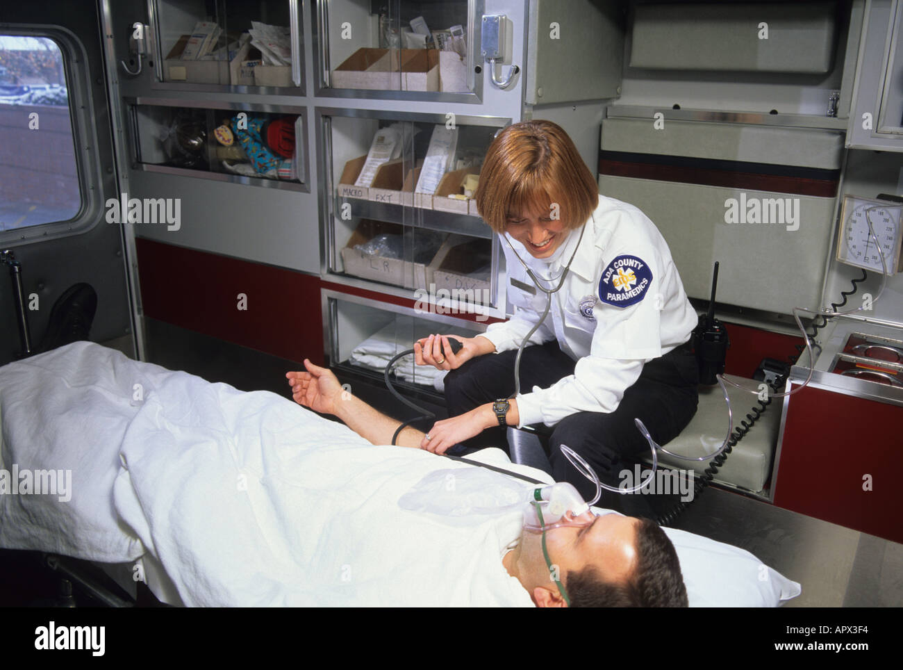 A female paramedic examines a patient inside an ambulance Stock Photo ...