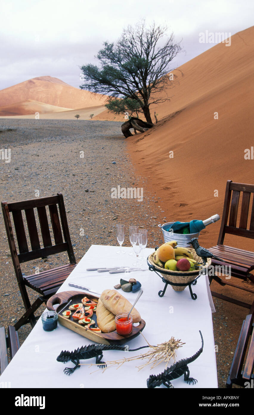 Table set for breakfast at the foot of a huge sand dune by Sossusvlei ...