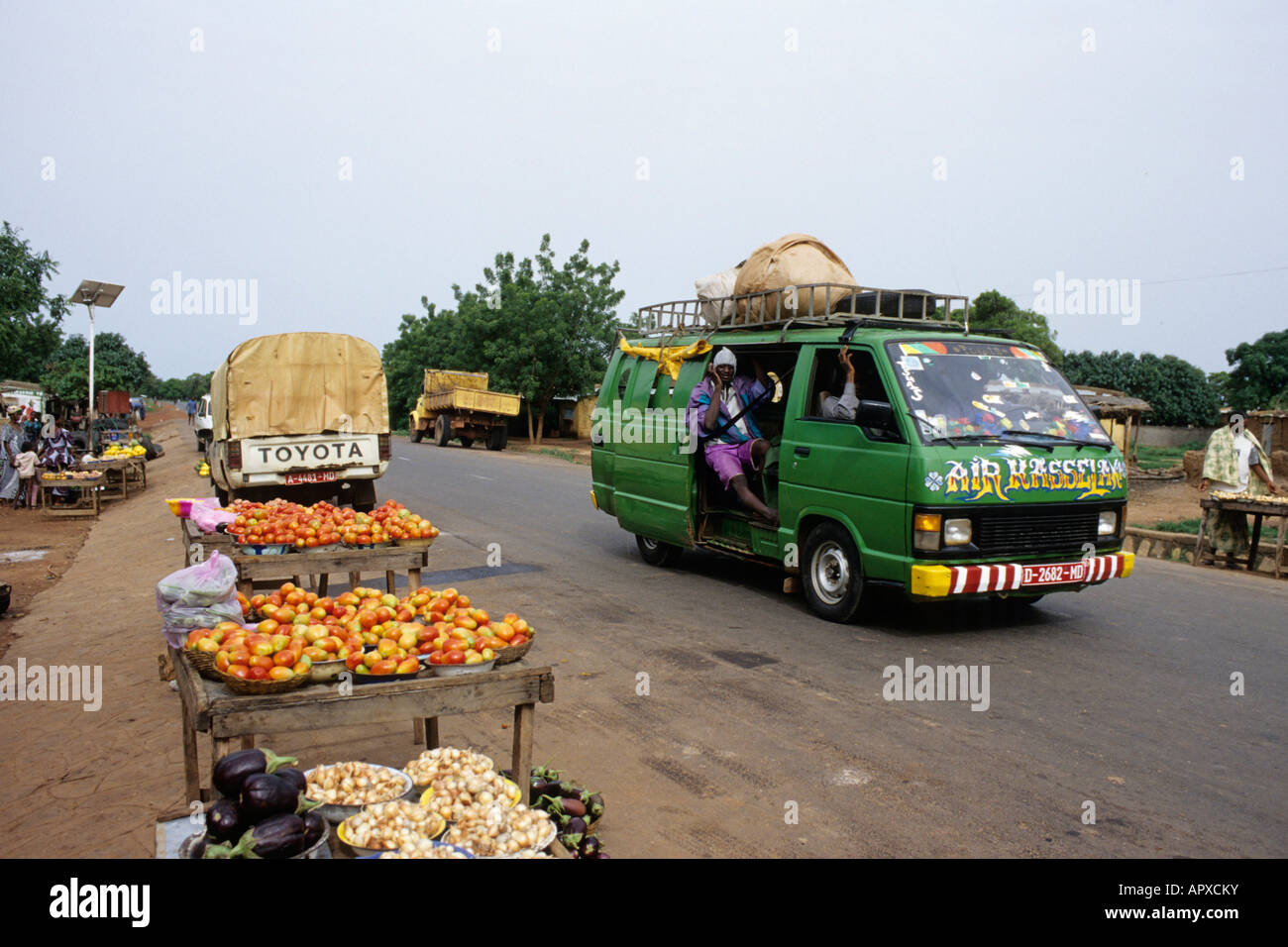 Vehicles on the main road with roadside stalls selling fresh produce ...