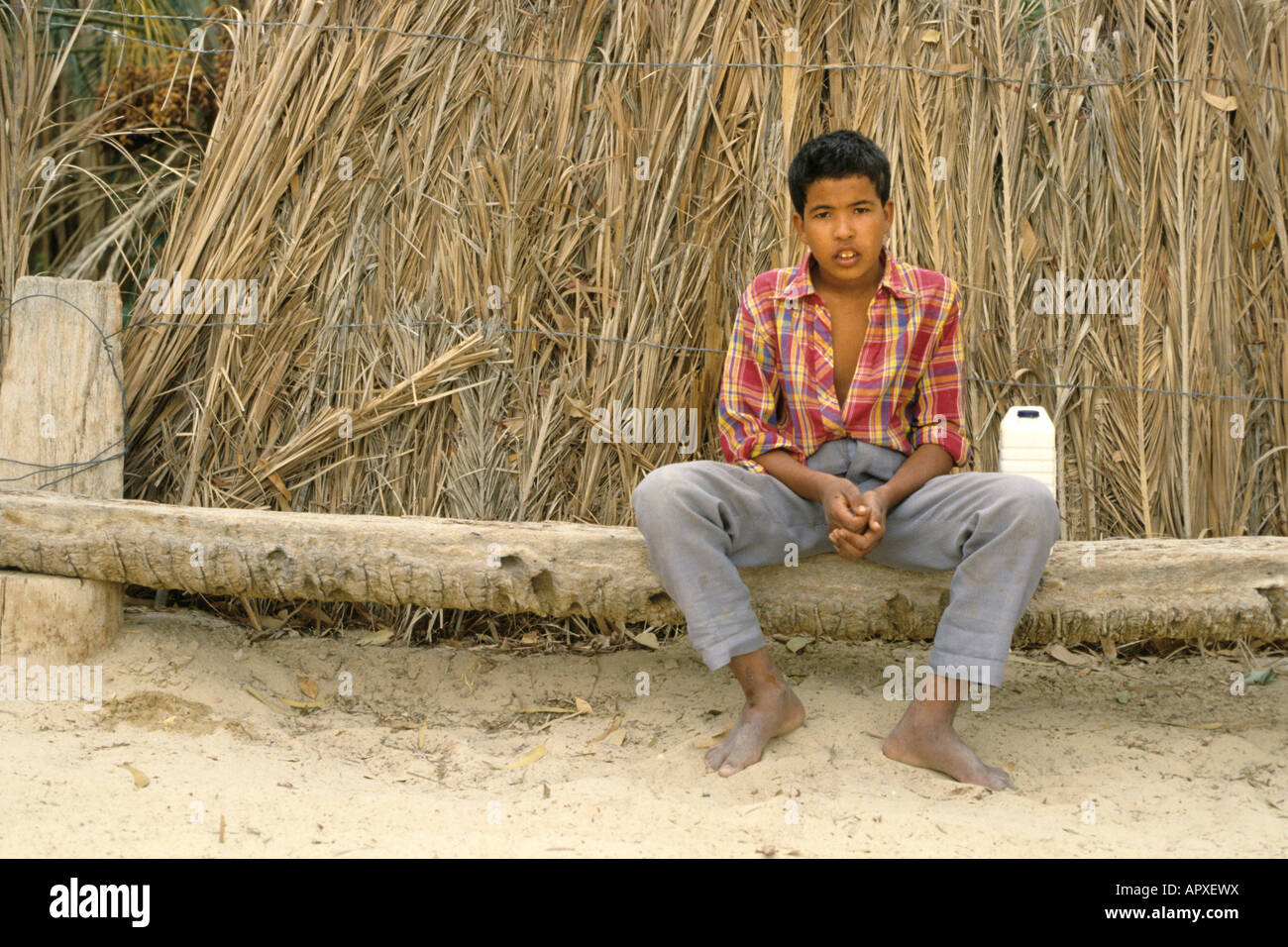 Little boy sitting on a makeshift bench in Nefta Stock Photo - Alamy